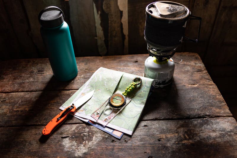 Tourist Items in the Hut. Knife, Map and Compass on the Table. Light ...
