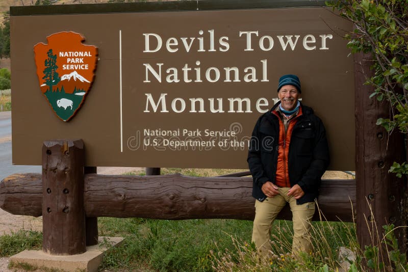 A Tourist Next the Sign of Devils Tower National Monument in Wyoming ...