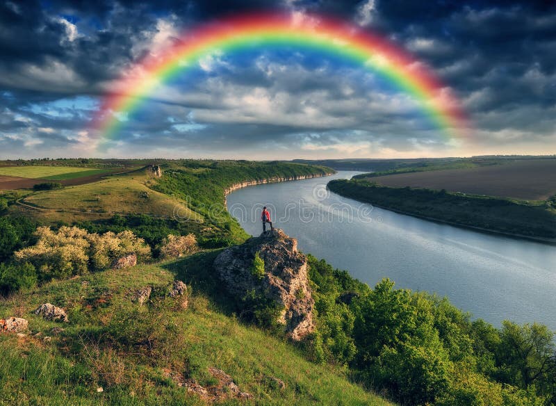 Tourist Standing on the Edge of the Cliff and Looking at the Rainbow ...
