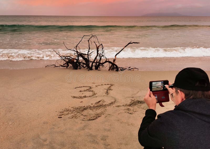 A Tourist Taking Photo of a Beach Sunset with Mobile Phone Stock Photo ...