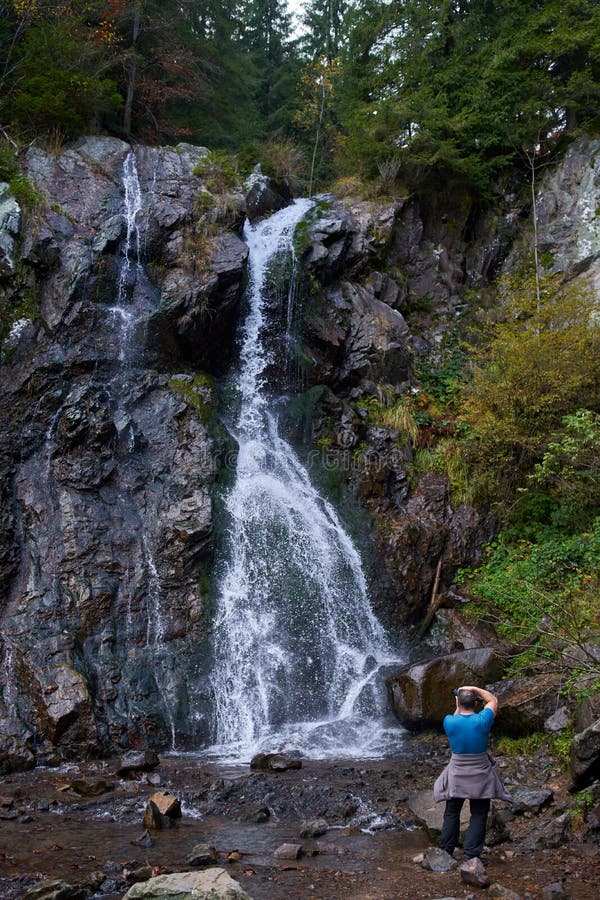 Tourist by the waterfall stock photo. Image of attraction - 204167800
