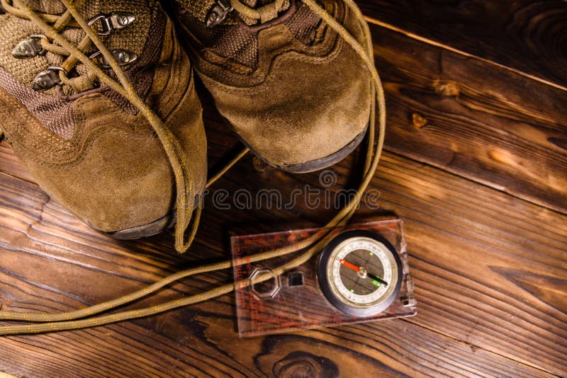 Touristic Magnetic Compass and Boots on Wooden Table Stock Image ...