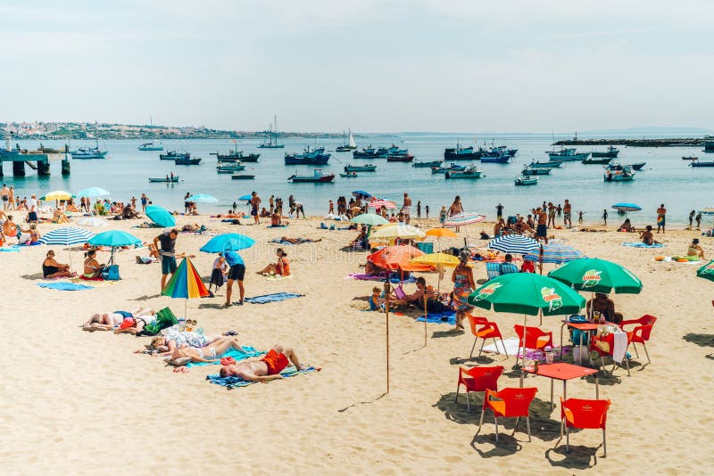 Tourists Having Fun in Water, Relaxing and Sunbathing in Cascais Ocean ... Tourists Having Fun in Water, Relaxing and Sunbathing in Cascais Ocean ...