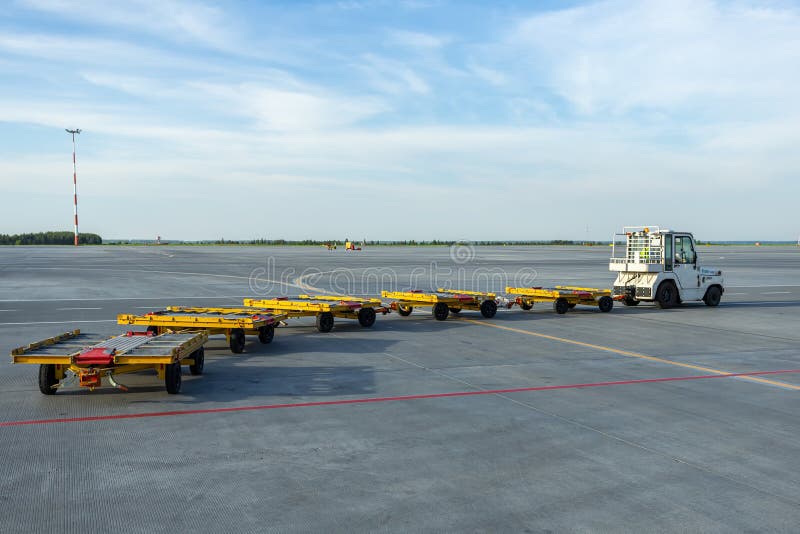 Tow Tractor Pulling Empty Luggage Carts at Airport Stock Photo - Image ...