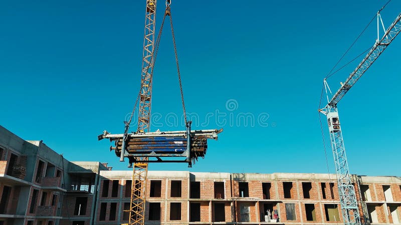 Tower Crane Lifting Construction Materials at a Building Site with ...