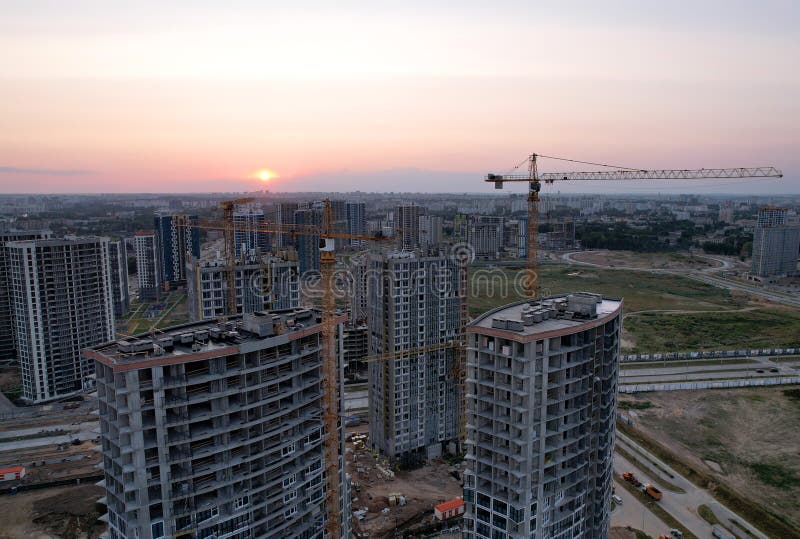 Tower Cranes in Action at Construction Site on Sunset Background. Arial ...