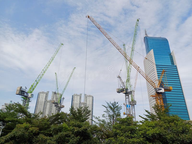 Tower Cranes at Building Construction with Buildings Background ...