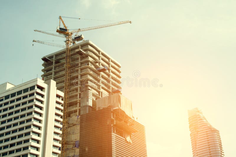 Tower Cranes on Top of Building Against a Sunset Sky. Stock Image ...