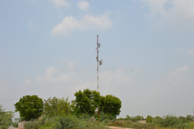 A Tower in the Middle of a Field with Trees and Bushes Stock Image ...