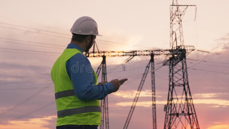 Tower Power Station Engineer. Male Engineer in a Hard Hat with a Tablet ...
