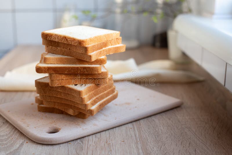 Tower of Slices of Toast Bread on Cutting Board in the Kitchen Stock ...