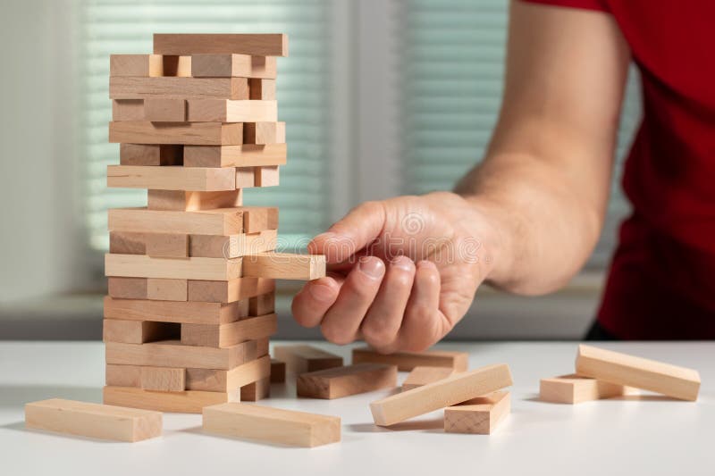 The Tower from Wooden Blocks and Man S Hand Take One Block Stock Image ...