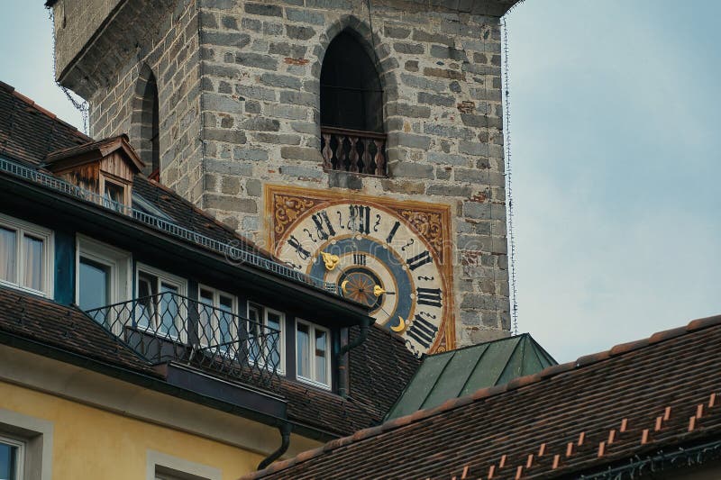 A Tall Clock Tower Sitting Next To a Building on Top of a Slope ...