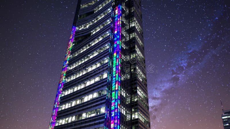 Towering Skyscraper with LED Light Display Against Starry Night Sky ...
