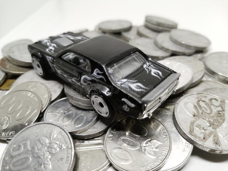 Toy Car on Top of a Pile of Coins Stock Photo - Image of pile, coins ...