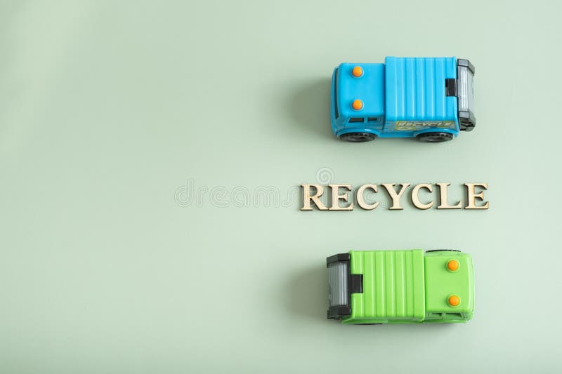 Toy Garbage Trucks and Recycle Text on a Green Background. Recycling ...