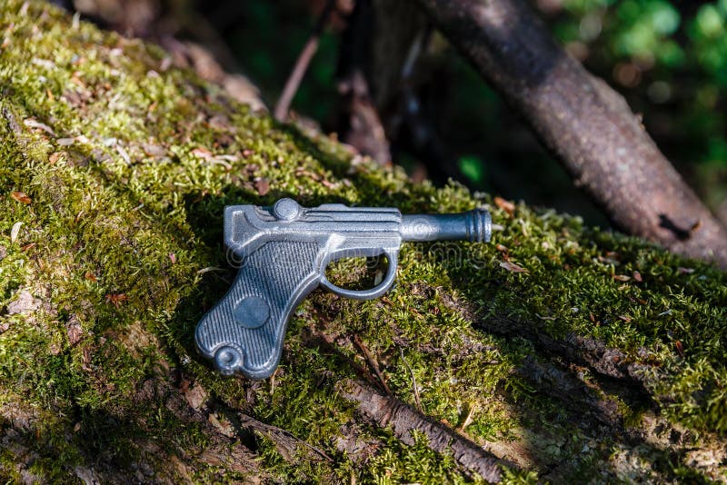 Toy Gun Made of Lead Lies on an Old Tree with Moss Stock Image - Image ...