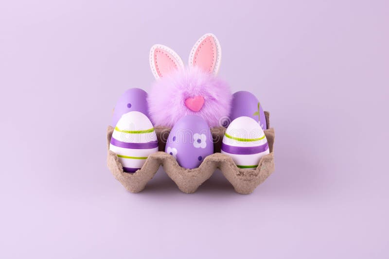 A Toy Lilac Fluffy Rabbit in an Egg Box, Easter Eggs are Lying Next To ...