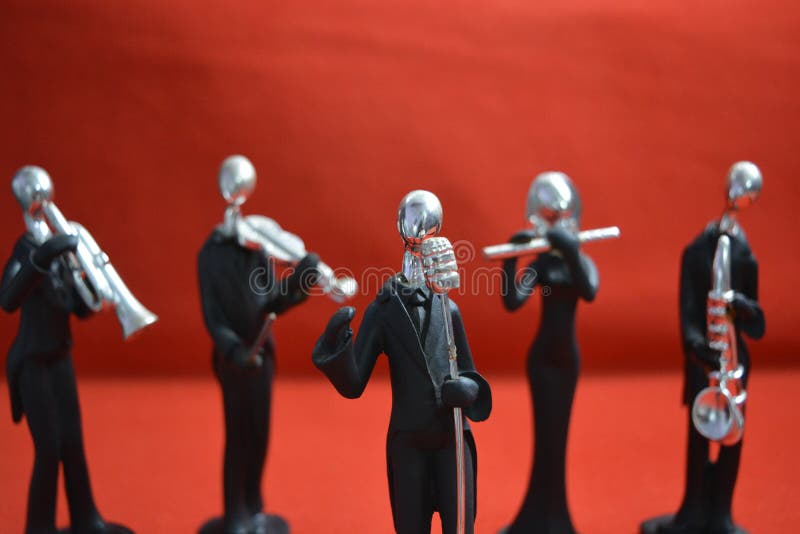 Toy Man with Microphone and Musicians on Red Background. Stock Photo ...