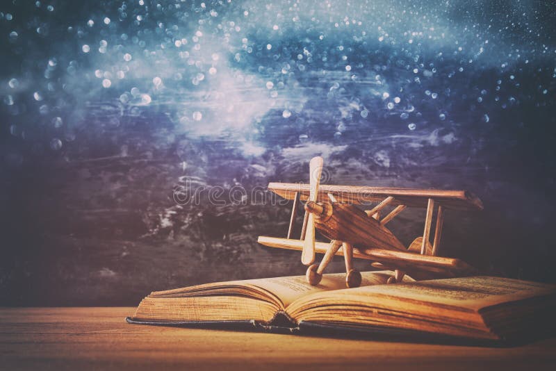 Toy Plane and the Open Book on Wooden Table with Glitter Lights Stock ...