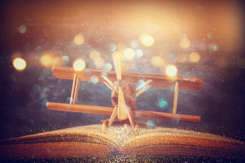 Toy Plane and the Open Book on Wooden Table with Glitter Lights Stock ...