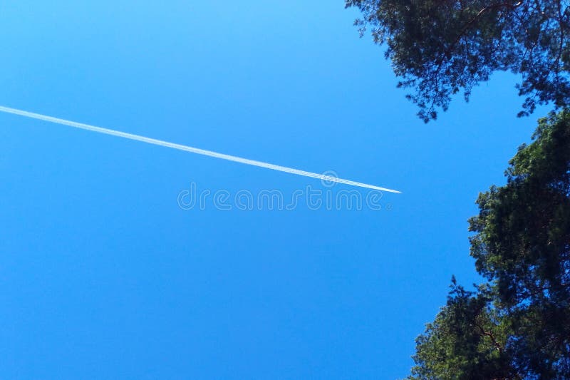 A Trace of a Flying Plane in the Blue Sky Stock Photo - Image of ...