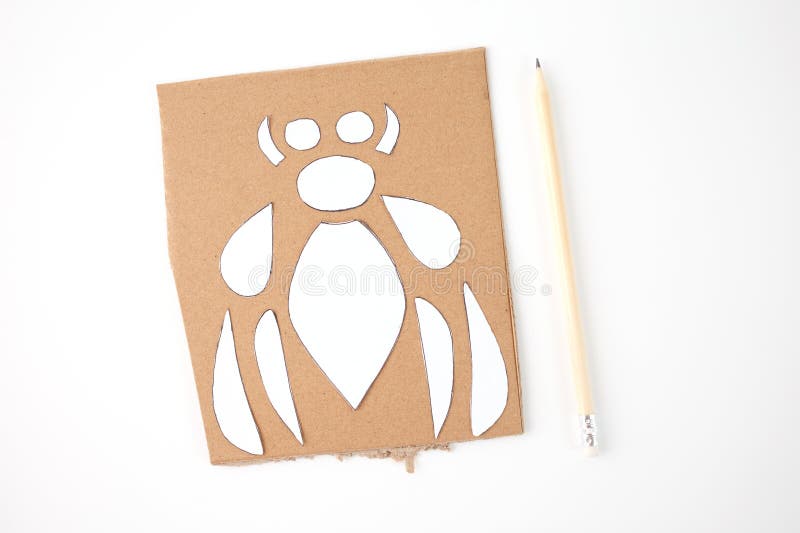 Tracing a Stencil of an Insect-like Shape Onto a Piece of Cardboard ...