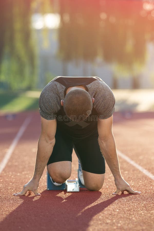 Track Runner in Starting Position on Sunny Morning. Stock Photo - Image ...