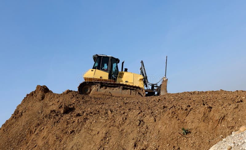 A Tracked Bulldozer is Flattening a Large Heap of Dirt. Stock Photo ...