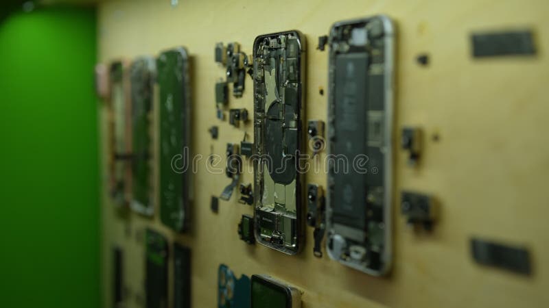 Tracking Shot of Disassembled Smartphones Displayed on Wooden Wall ...