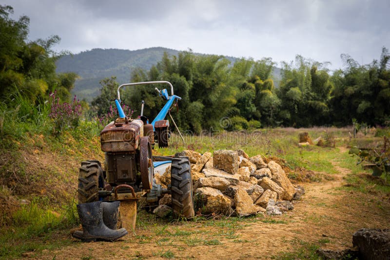 A Tractor with Buckets on the Front is in Front of a Rock Wall Stock ...