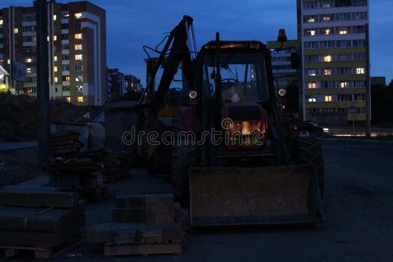 Tractor in the City on Construction Repair Work in the City at Night in ...