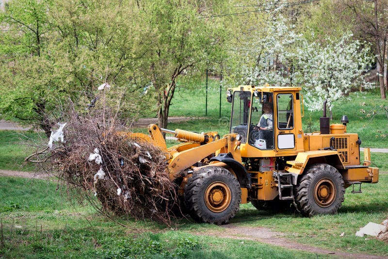 A Tractor with a Clamp instead of a Bucket Cleans Away Garbage, Stock ...