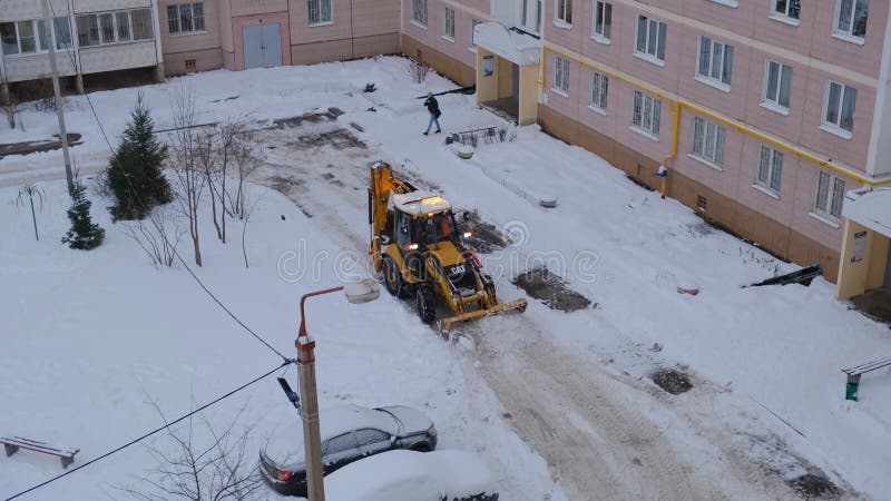 Tractor Cleaning the Yard of a Multi-storey Building after a Snowfall ...