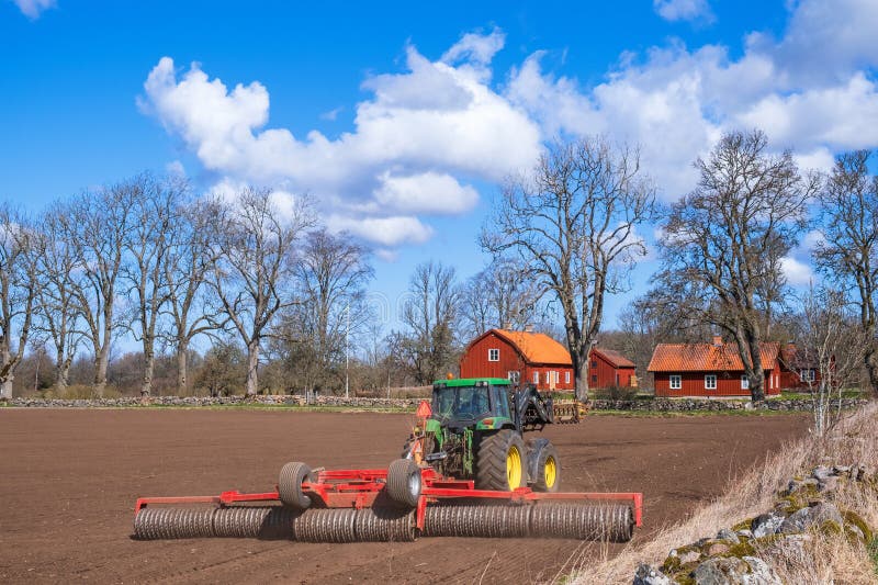 Tractor with a Cultipacker on a Field by a Farm Editorial Stock Photo ...