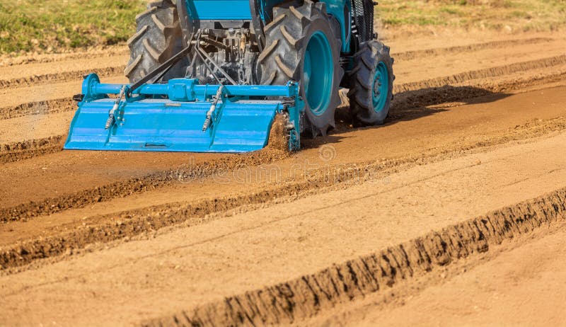 Tractor Cultivating Land with a Rotary Tiller in Farm Stock Photo ...