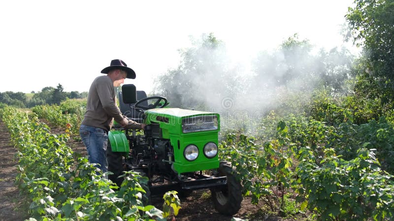 The Tractor Driver Starts the Diesel Engine in the Middle of the Field ...