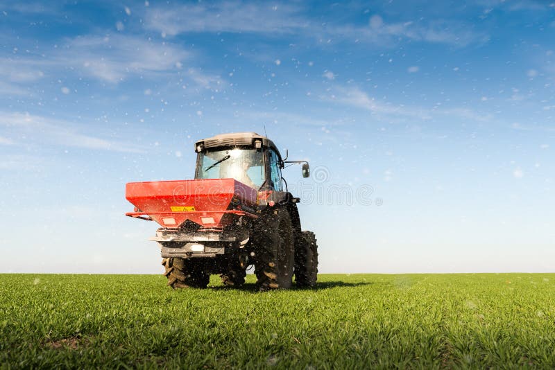 Tractor Fertilizing in Field Stock Photo - Image of farmland, spreader ...