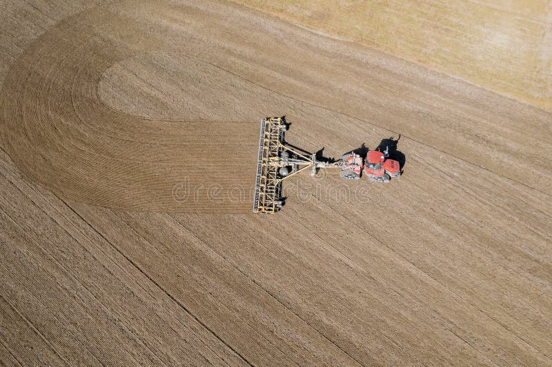 A Tractor in the Field Sows the Ground with Grain. Stock Photo - Image ...