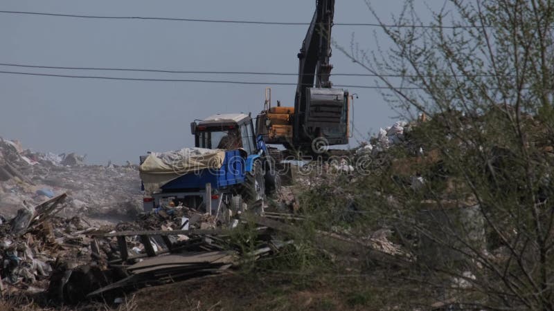 A Tractor with Garbage Drives through a Solid Waste Landfill. Garbage ...
