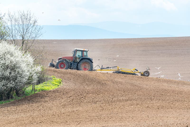 Tractor Harrowing the Field Stock Photo - Image of industrial, green ...