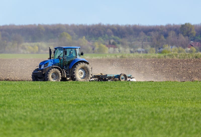 Tractor harrowing the land editorial photography. Image of cultivation ...