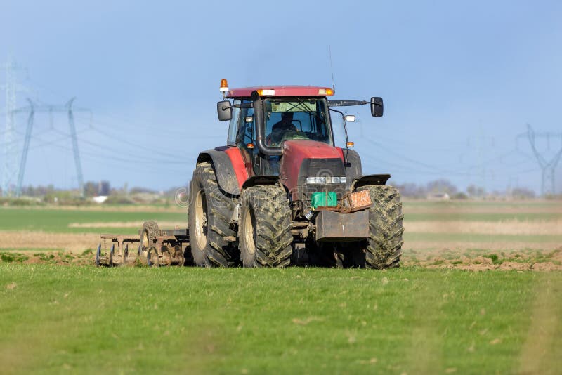 Tractor harrowing the land editorial photography. Image of machine ...