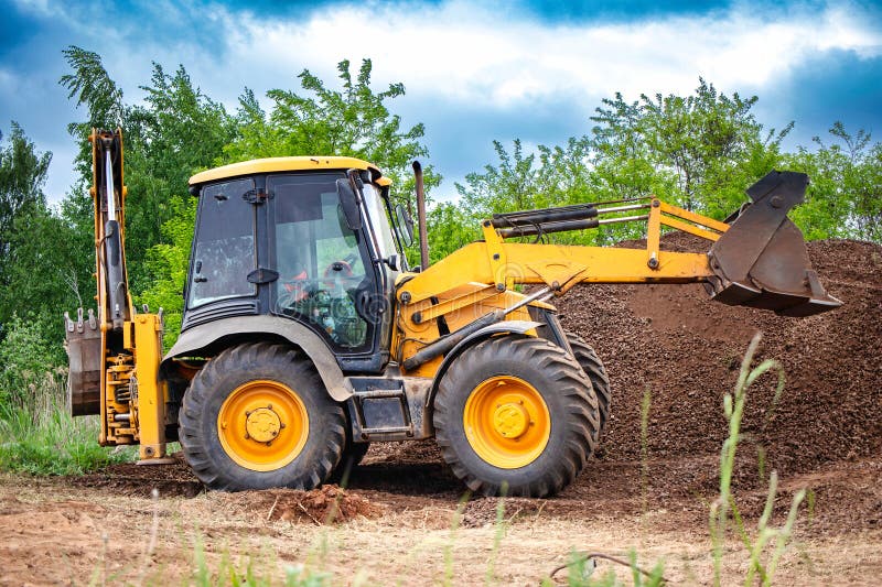 A Tractor or a Loader is Dumping Dirt in a Field, Creating a Pile of ...