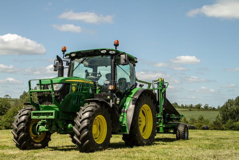 Un Tractor De John Deere Y Un Remolque Verdes De Bailey Imagen ...