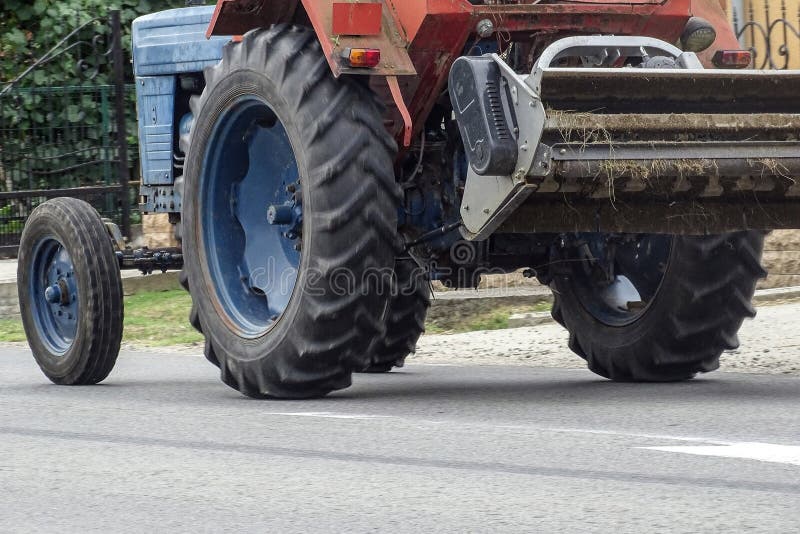 A Tractor Moves on the Road during the Summer Stock Photo - Image of ...