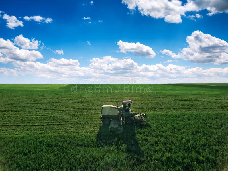 Tractor mowing green field stock image. Image of field - 77896123