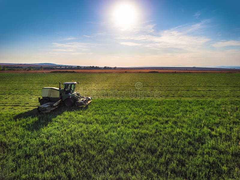 Tractor mowing green field stock photo. Image of landscape - 78537874