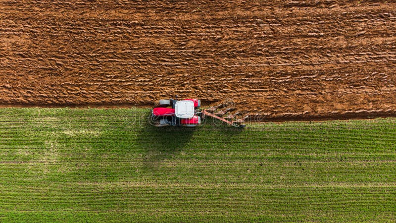Tractor Ploughing a Meadow of Green Grass. View from Above with a Drone ...