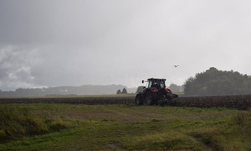 Tractor with Plow on Field in Bad Weather Stock Photo - Image of dark ...